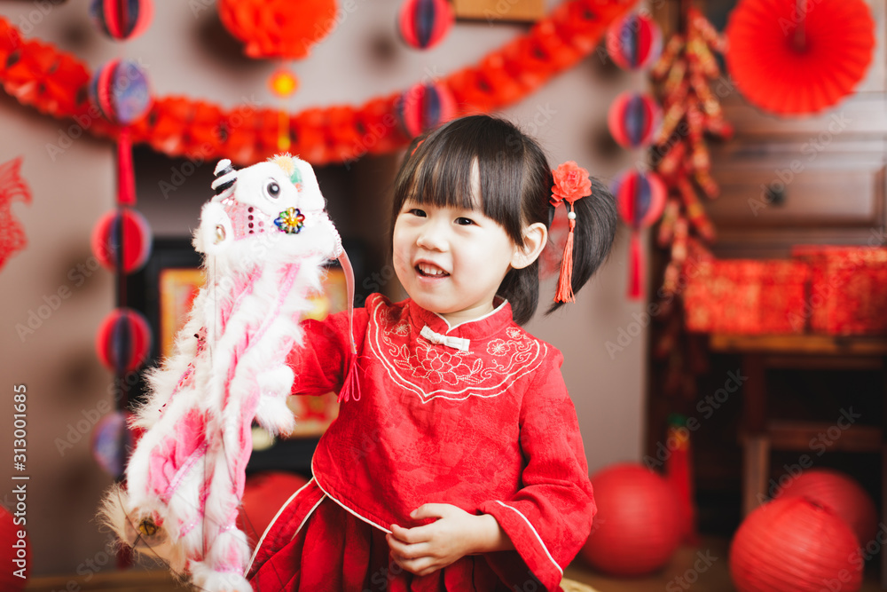 Chinese baby girl with traditional dressing up and holding dancing lion ...