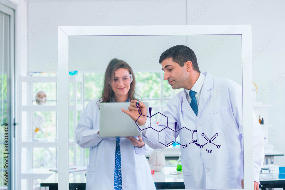 general-view of two people analyzing a citric acid molecular model in a ...
