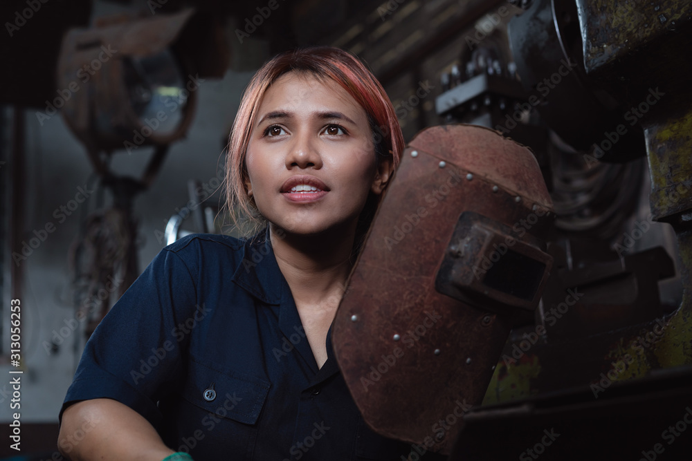 Diverse female industrial engineer holding welding helmet after work ...