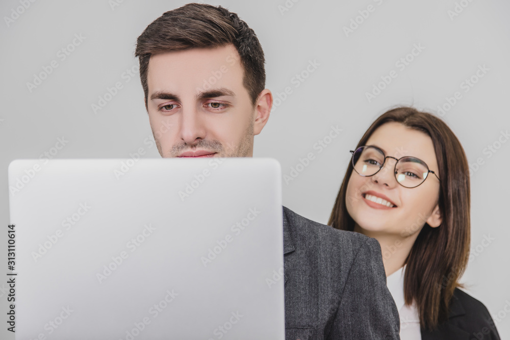 Businessman standing, working with laptop. Inquisitive woman is looking ...
