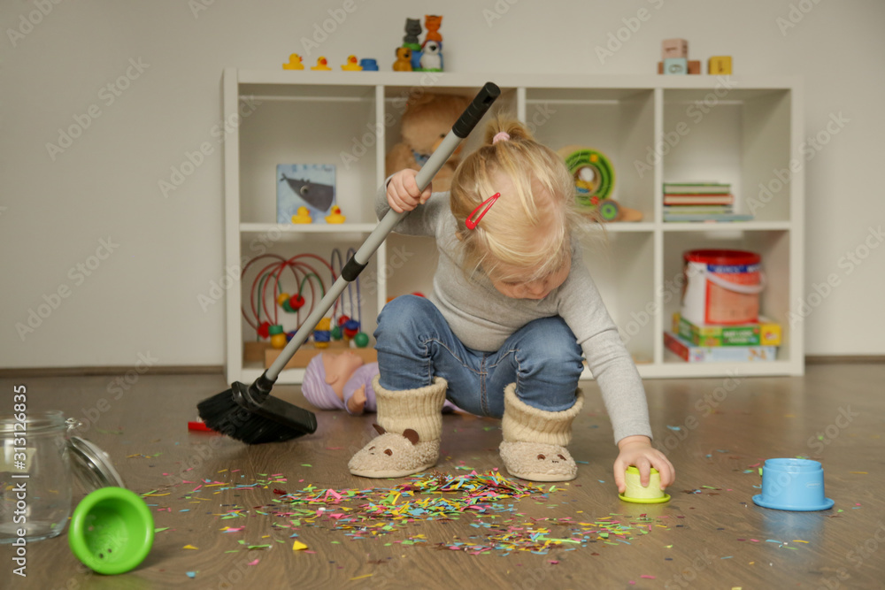 Adorable blonde toddler girl playing with broom, cleaning colorful ...