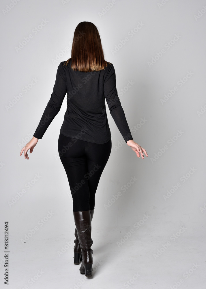 full length portrait of a pretty brunette girl wearing a black shirt ...