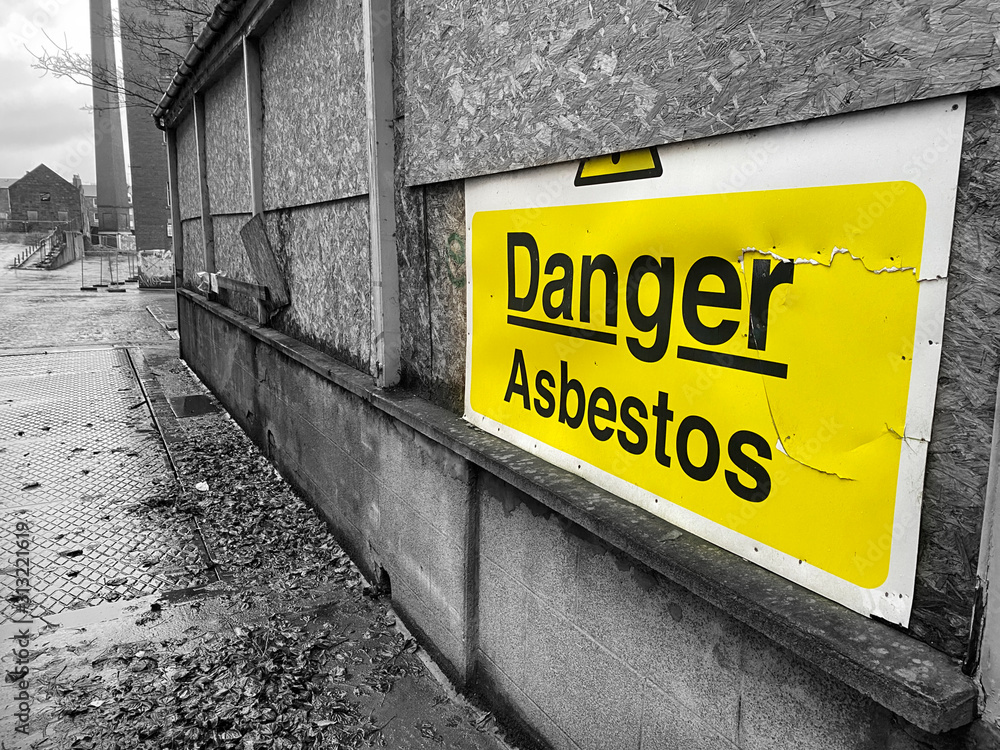 Asbestos danger sign at building construction site refurbishment of old ...