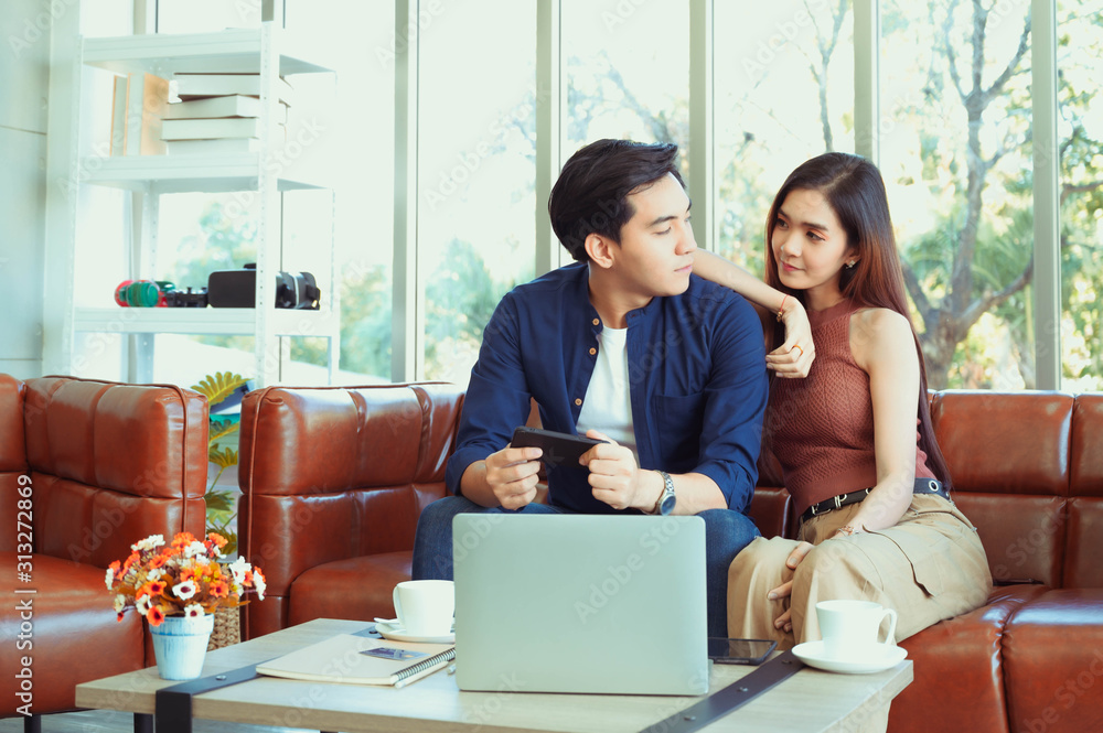 Couple at home relaxing in sofa. Portrait of a cute young couple ...