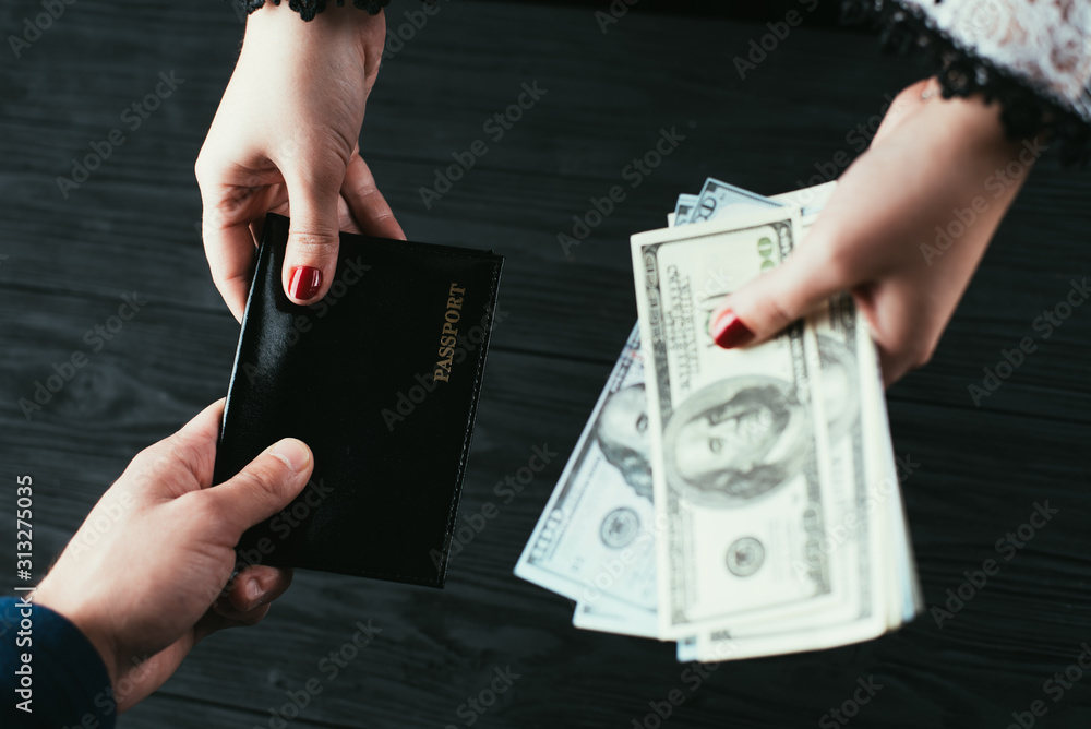 On a black wooden background, a top view of a hand handing over a ...