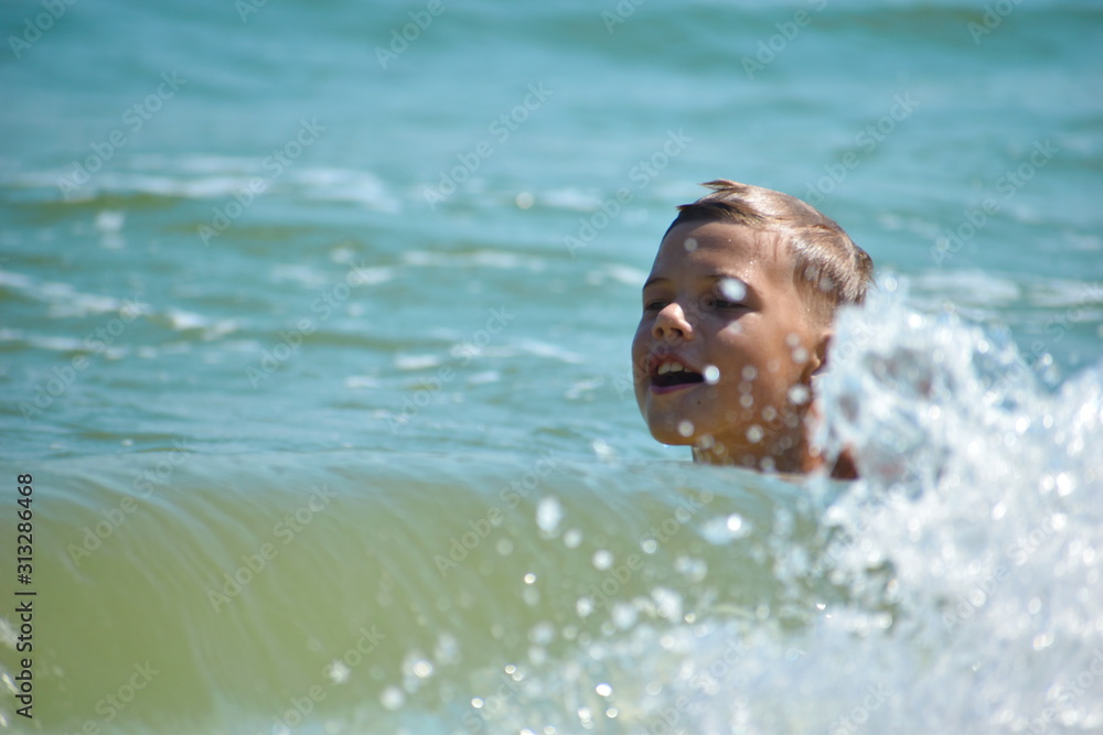 Boy child swim in sea. A boy swims in the open ocean. Learning to swim ...