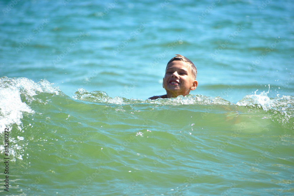 Boy child swim in sea. A boy swims in the open ocean. Learning to swim ...