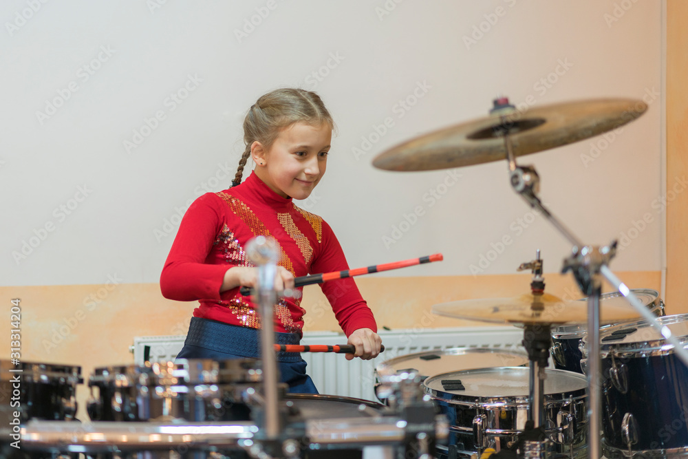 Teen girl playing the drums. Teen girls are having fun playing drum ...