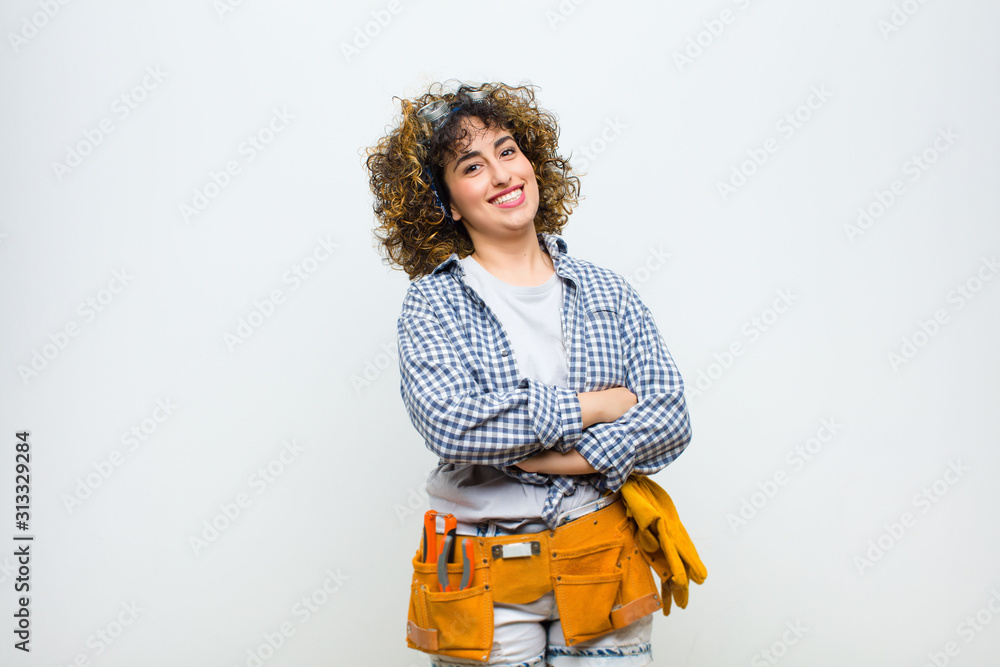 young housekeeper woman laughing happily with arms crossed, with a ...