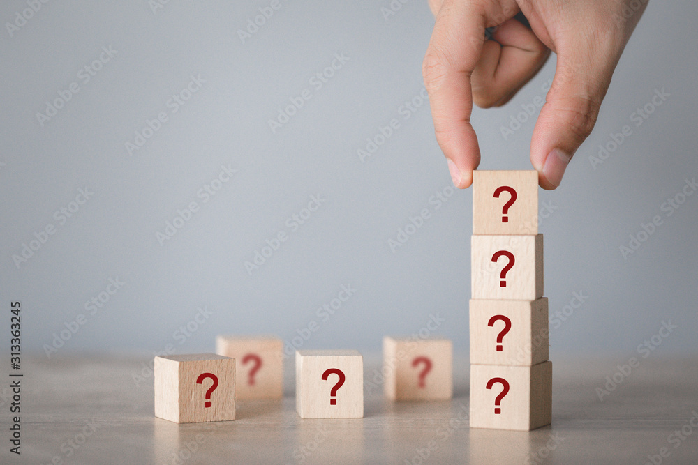 Hand arranging wood block stacking with icon question mark,thinking ...