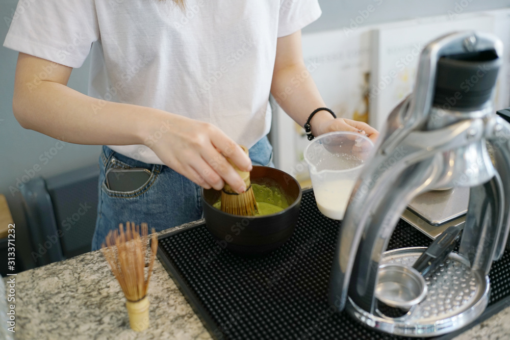 Girl making matcha latte, green tea with milk, traditional matcha tools ...