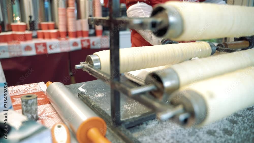 Cooking a traditional european sweet bun in a street market. Trdelnik ...