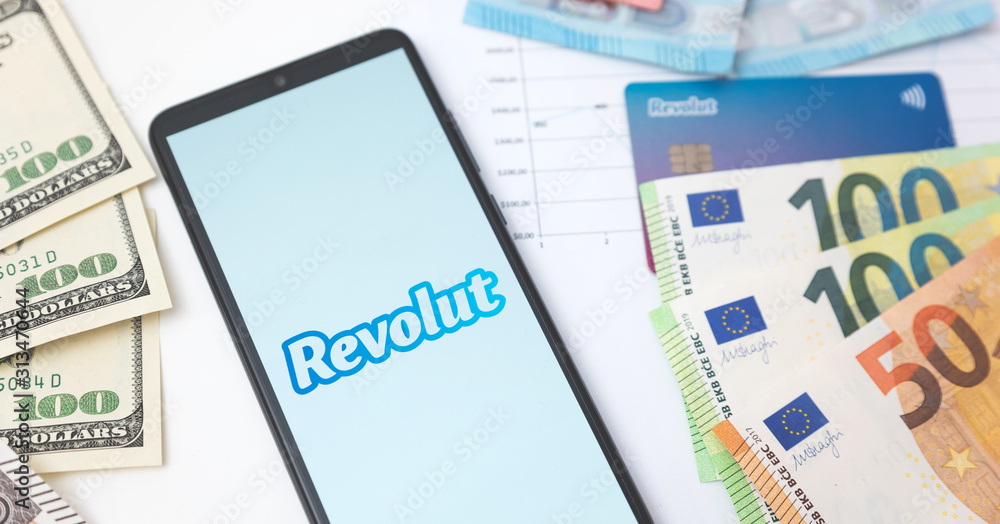 Revolut bank logo on phone screen and currencies Stock Photo | Adobe Stock