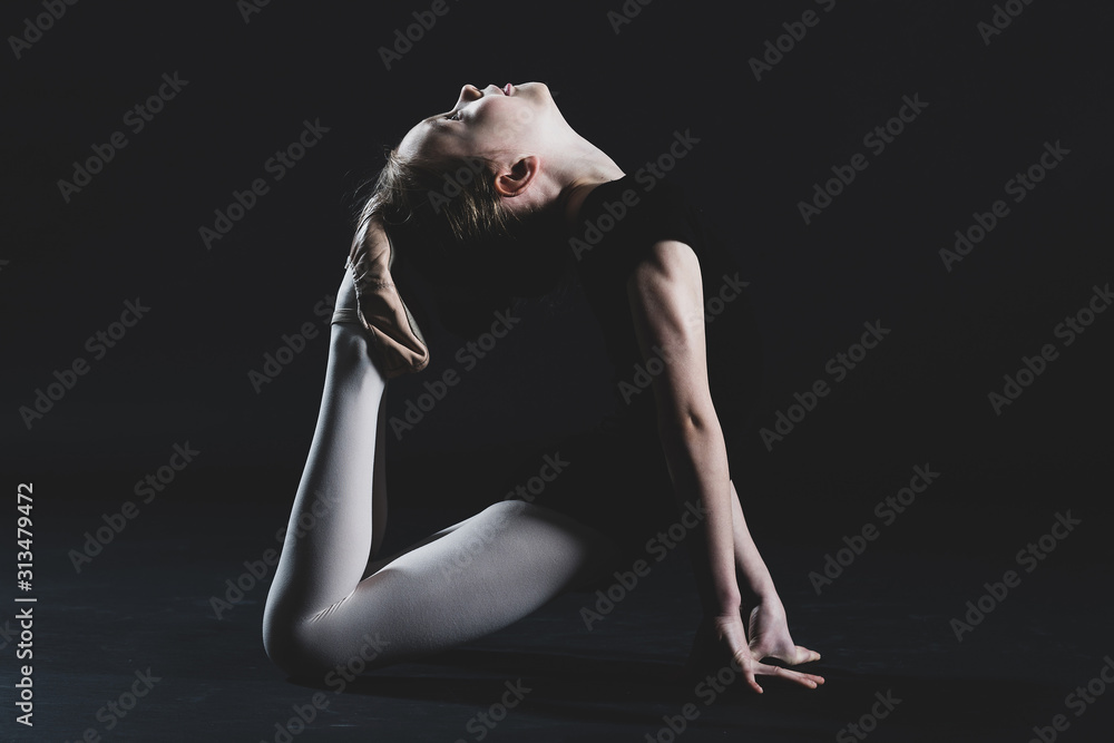 Young girl flexing her back touching toes to forehead for portrait ...