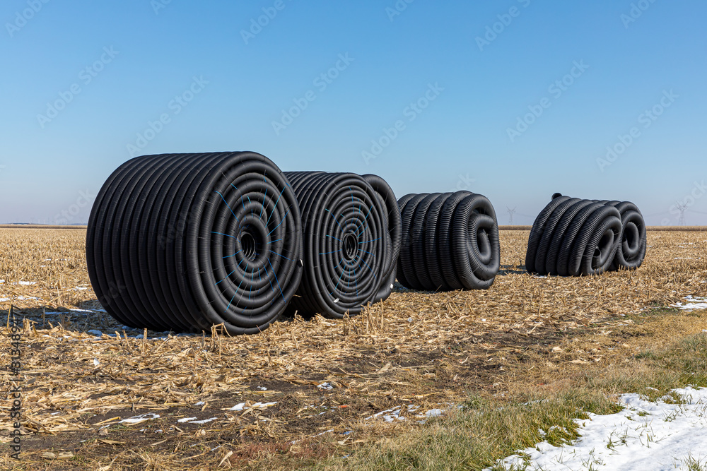 Coiled rolls of black perforated plastic drainage pipe, field tile ...