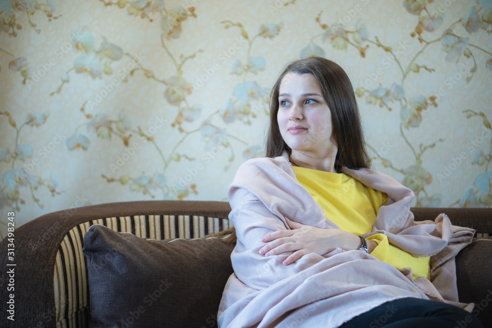 Fotka „A picture of nice and thoughtful girl sits at sofa and reads a ...