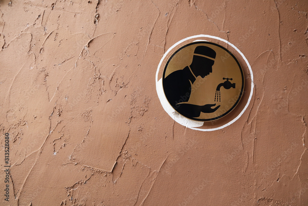Sign of ablution room for washing parts of the body using water before ...
