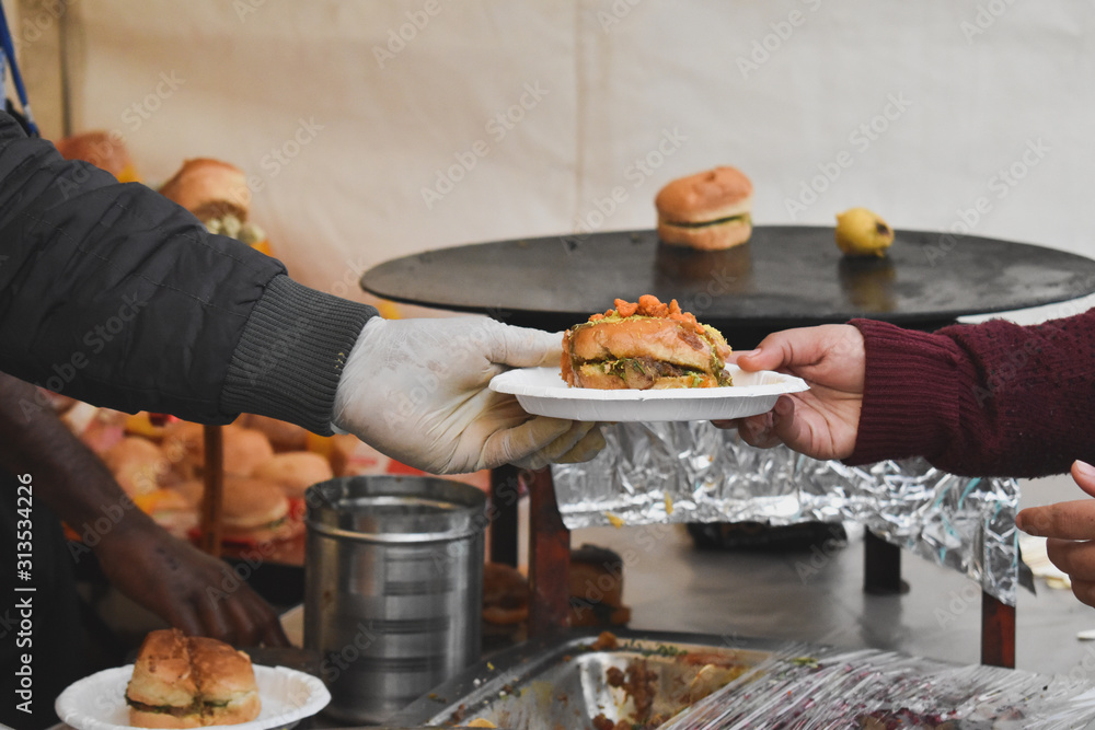 Food stall worker serving food to customer Stock Photo | Adobe Stock