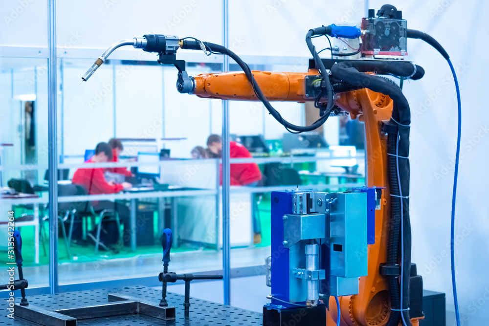 Metalworking. Robotics. Programming of robots. The orange arm of the ...