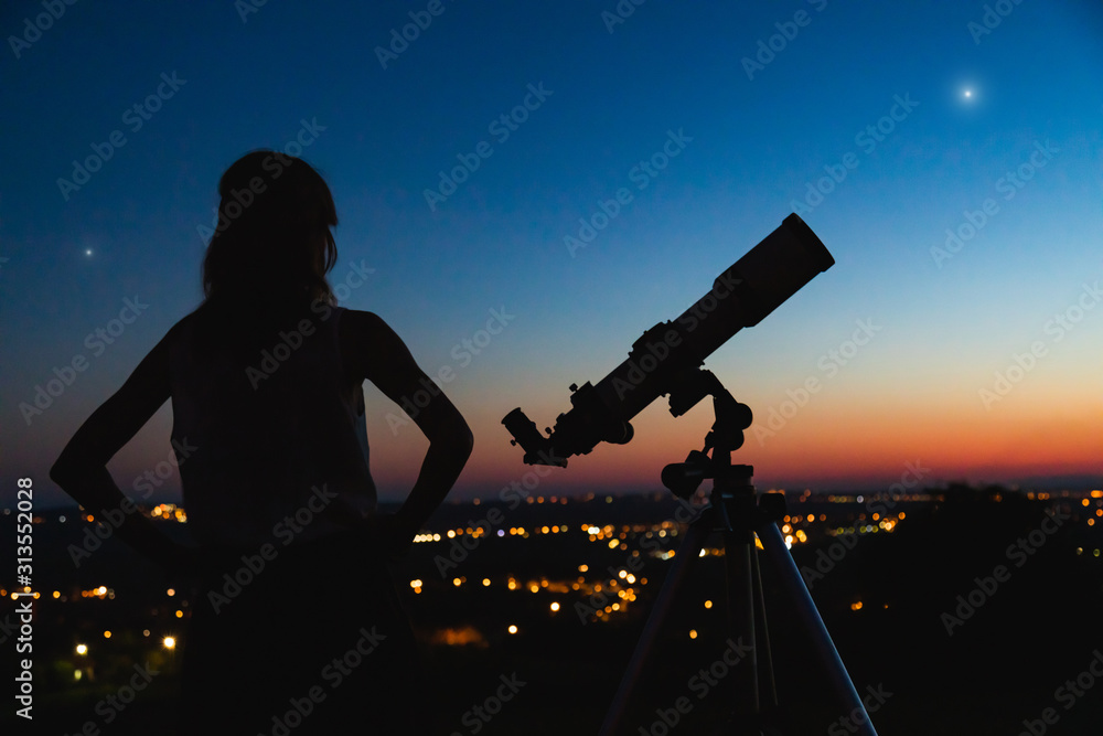 Astronomer with a telescope watching at the stars and Moon with blurred ...