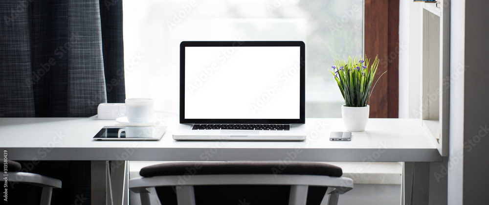 Office desk next to a window with laptop and tablet pc and a smart ...