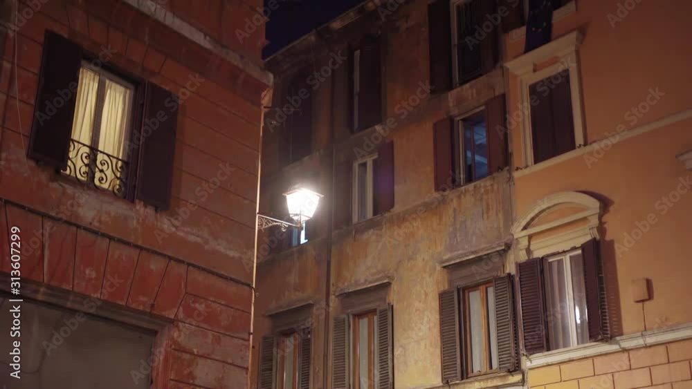 Antique lamp hanging on the Roman street and illuminating road, high ...