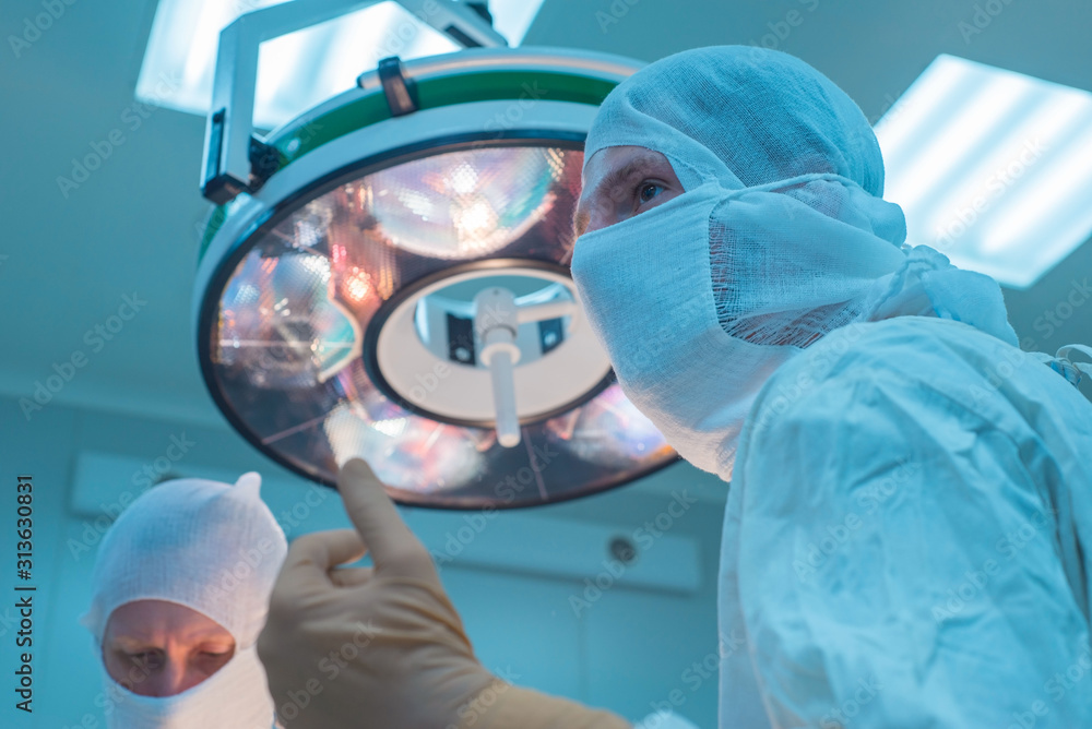 bottom view of surgeons in the operating room, in sterile masks ...