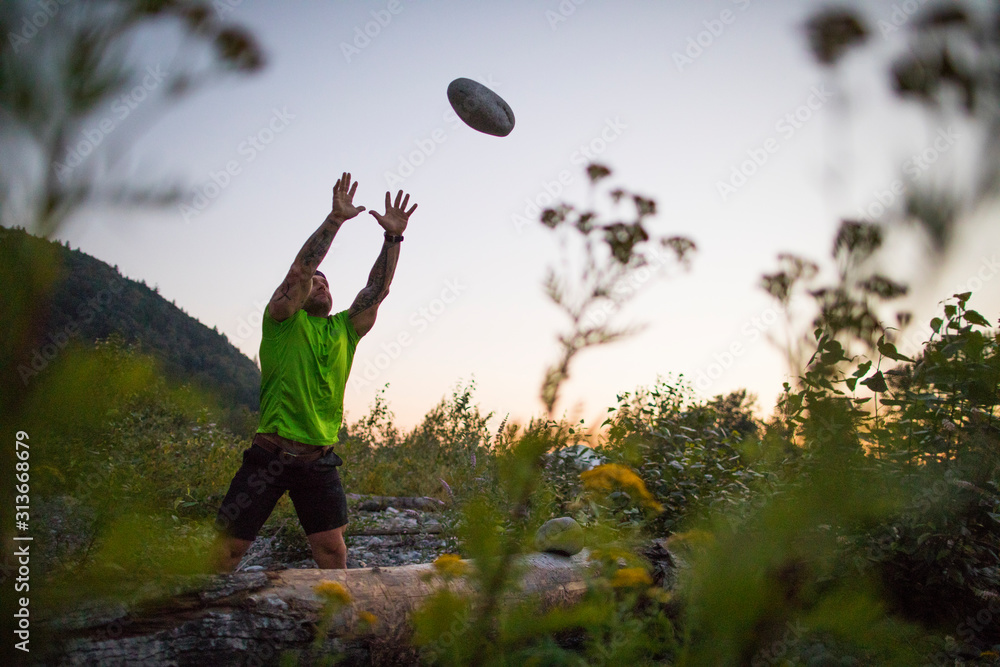 bodybuilder throws boulders during a strength training exercise. Stock ...