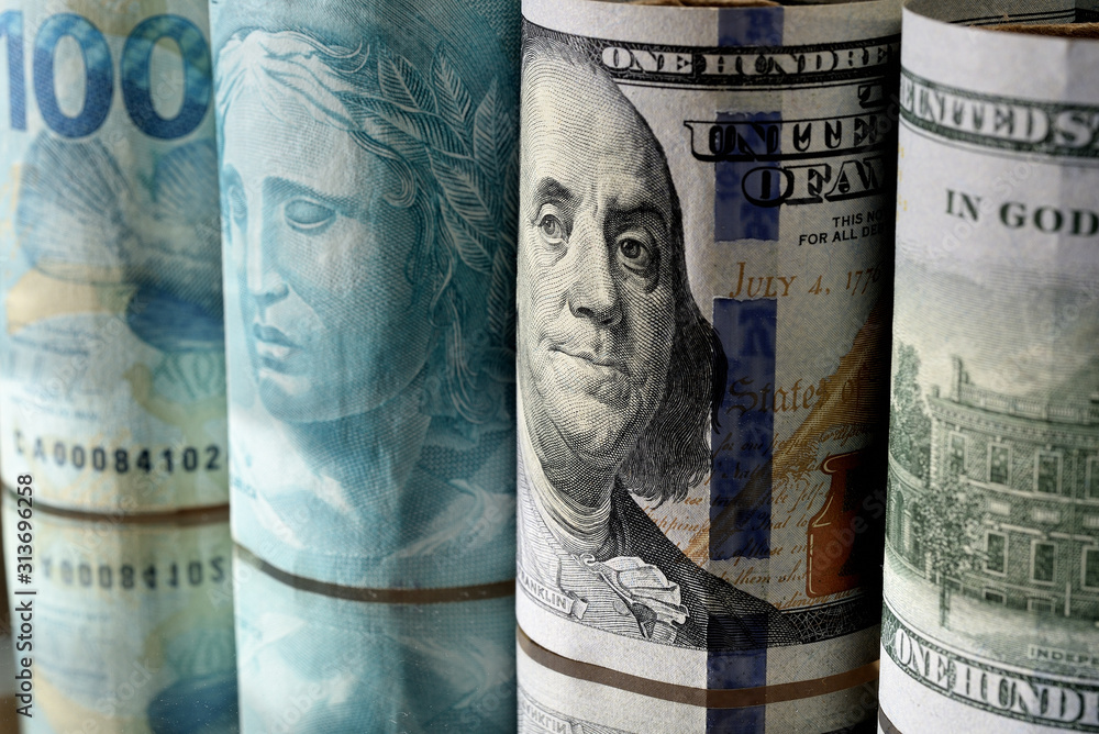 Conjunto de Notas de Cem Reais junto a notas de Cem Dólares em rolos ...