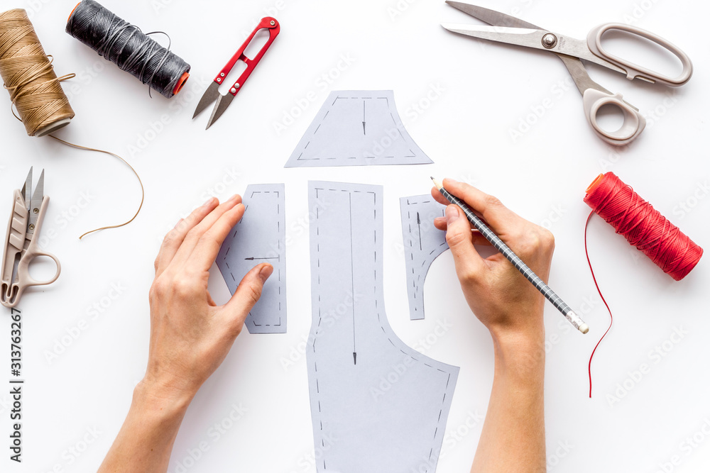 Tailor working. Women hands drawing patterns for clothes on white ...