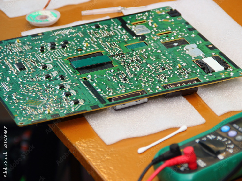 Digital electronics repair, modern TV PCB motherboard on table on ...