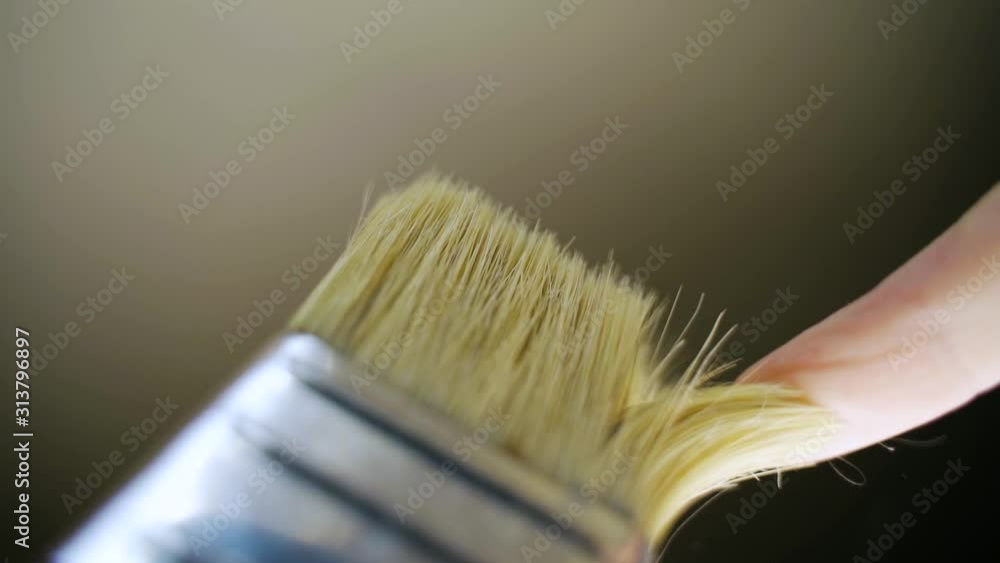 Fingers brushing a dry dusty paint brush close up. Slow motion. Check ...