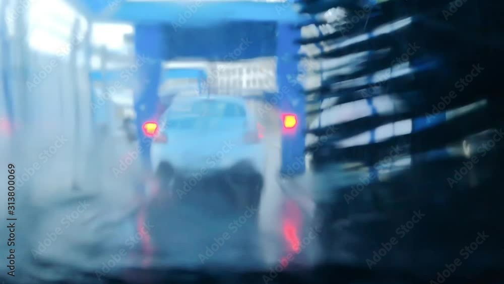 Car washing in automatic car wash, point of view from inside through ...