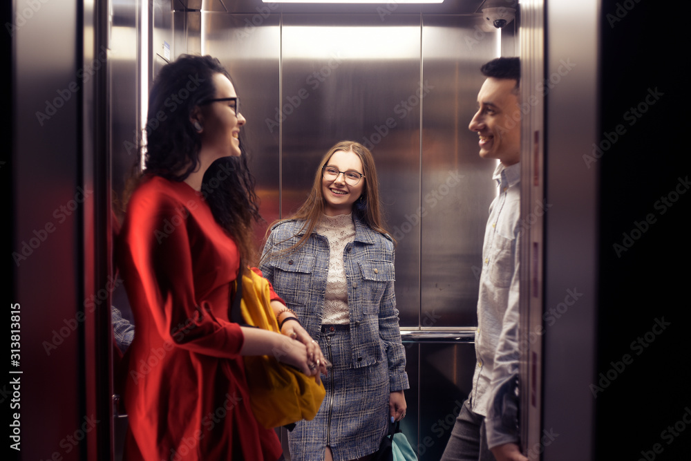 The girls and the guy ride in the elevator. Students in the elevator go ...