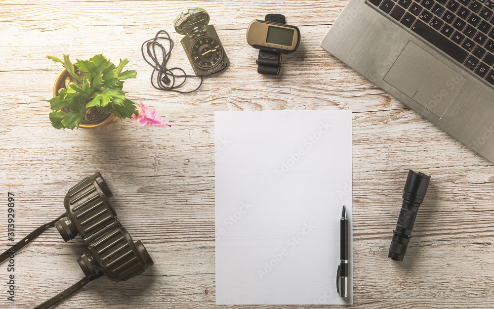 bright wooden office desk with laptop, gps, and empty scheet of paper ...