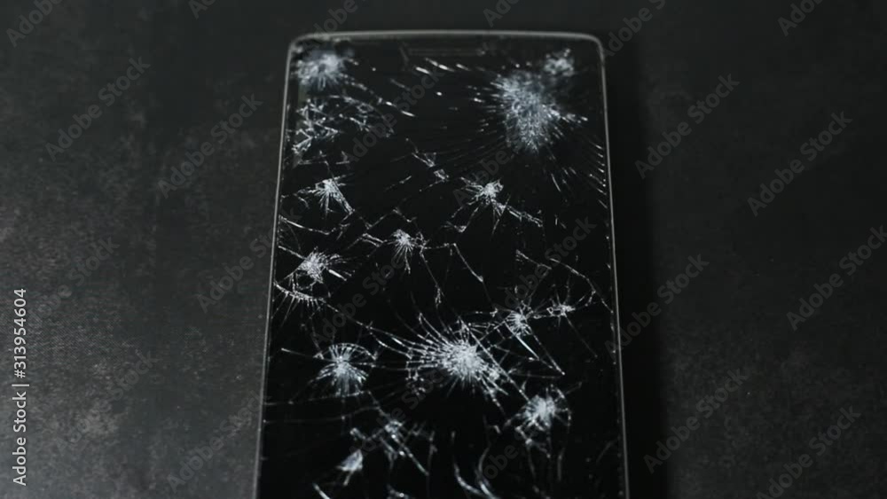 Vidéo Stock A broken phone on black background. Crushed device with ...