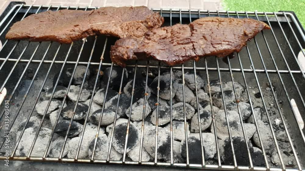 Vidéo Stock Barbecue bbq Grill with stainless steel tongs laying down ...