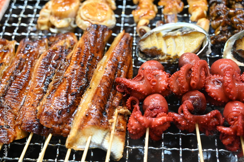 Different types of fish, octopusses and crabs on a grill in a market in ...