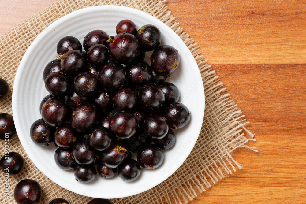Foto de Jabuticaba in the bowl on jute - top view. Jaboticaba or ...