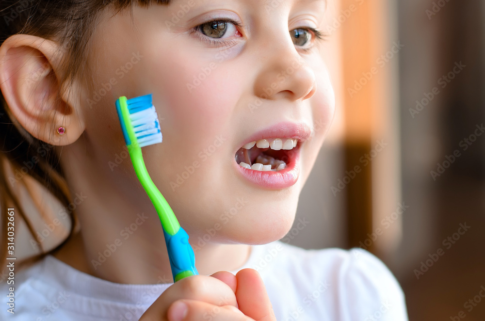 Beautiful smiling preschool girl with her first adult incisor tooth ...