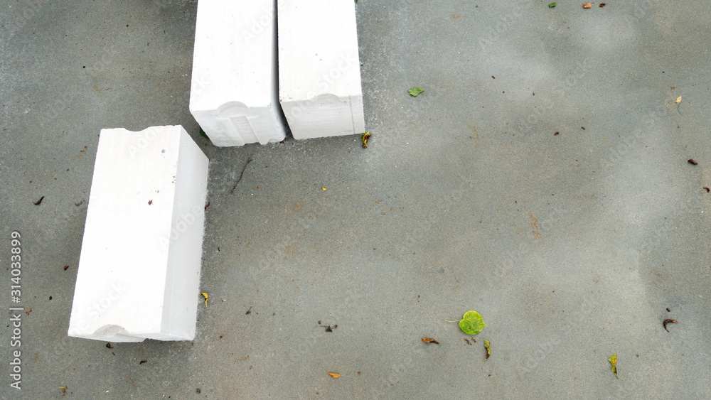 White foamed lightweight concrete block laying on concrete floor ...
