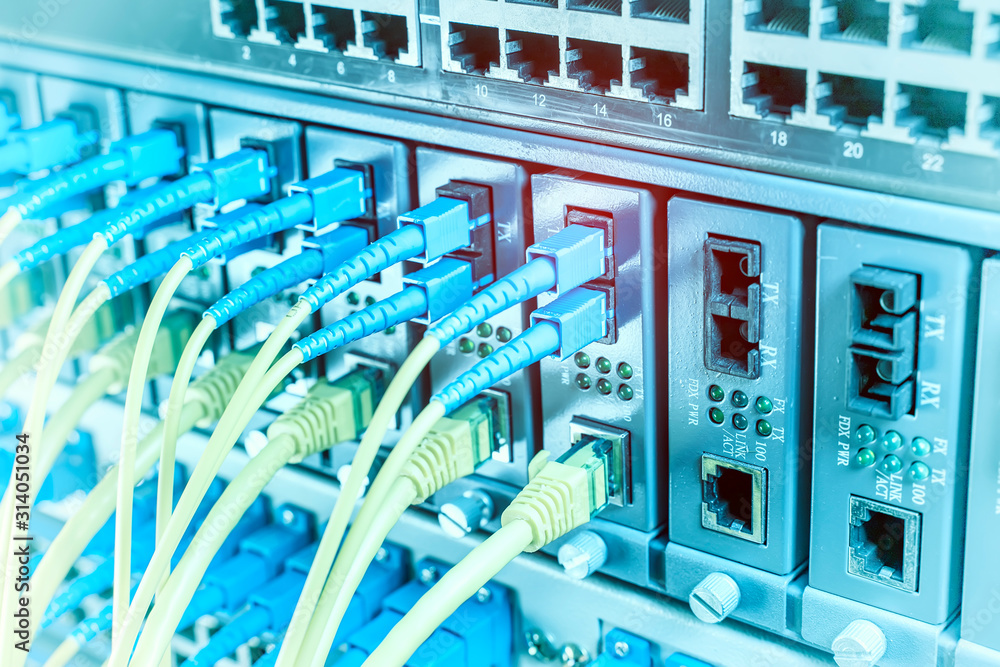 Fiber Optic cables connected to an optic ports and Network cables ...