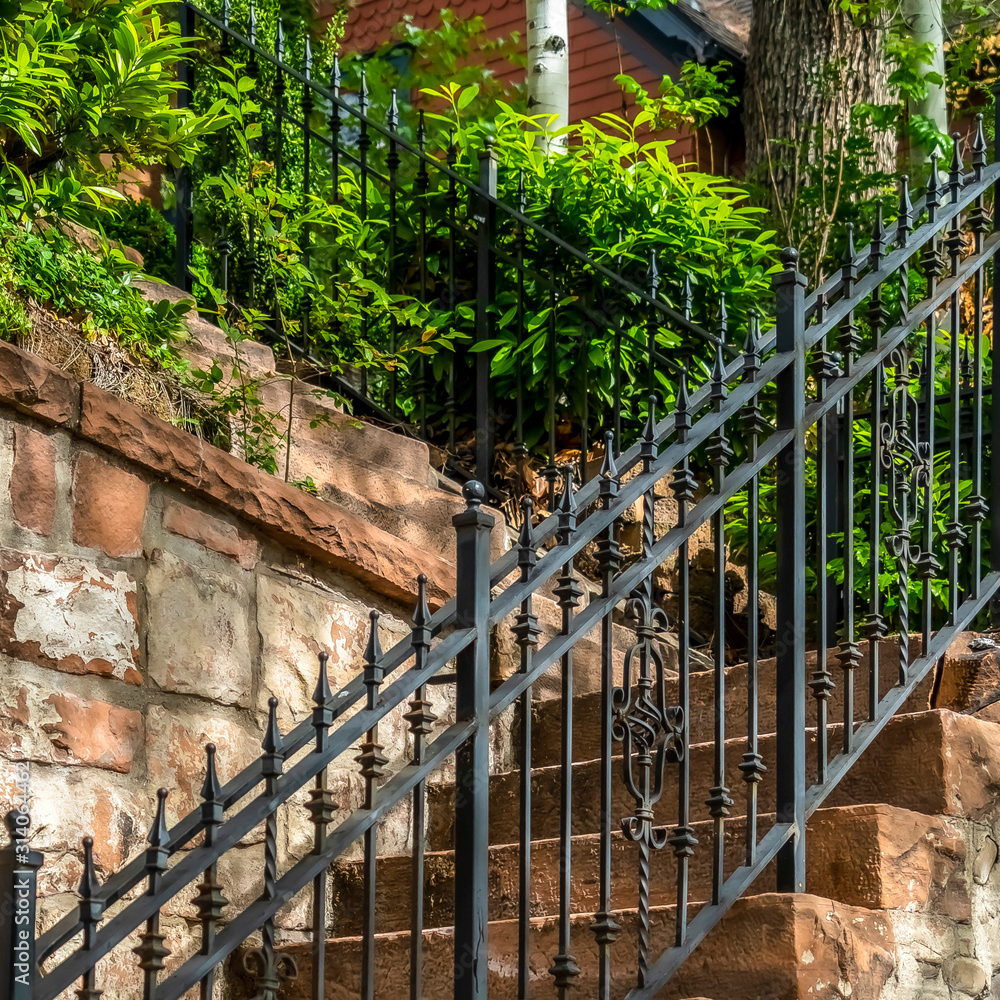 Square frame Outdoor staircase with stone steps and black metal railing ...