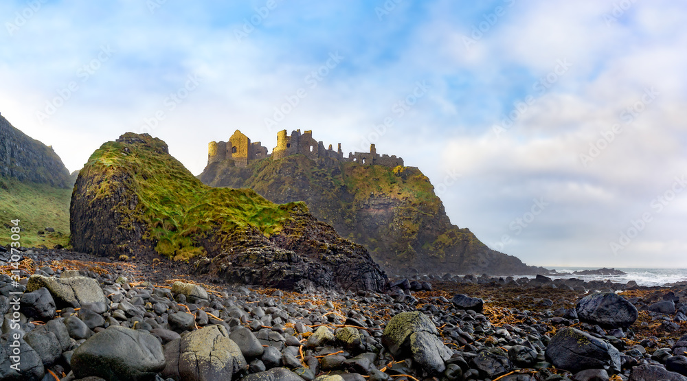 Ruined medieval Dunluce Castle on the cliff dramatic sky. Part of Wild ...