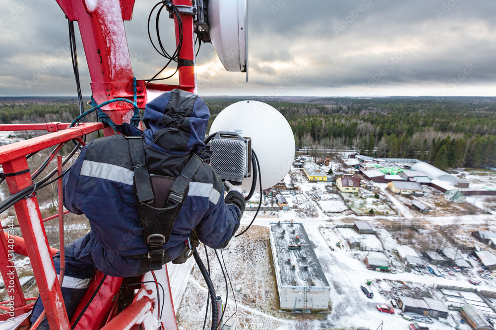 Professional industrial climber in uniform and climber equipment on the ...