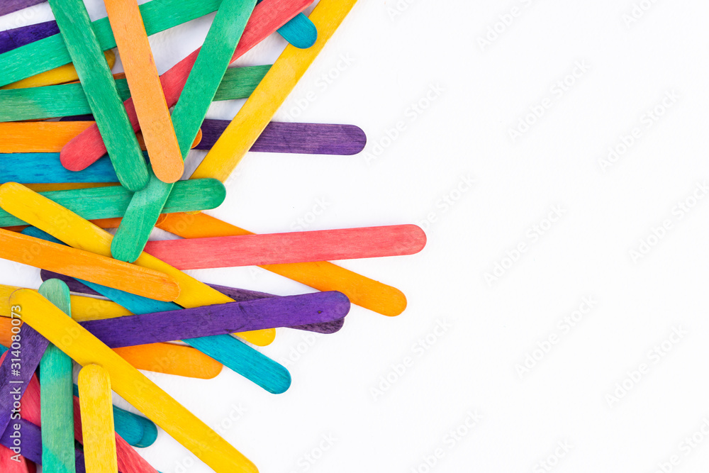 Colorful rainbow wooden popsicles on white paper background with copy ...