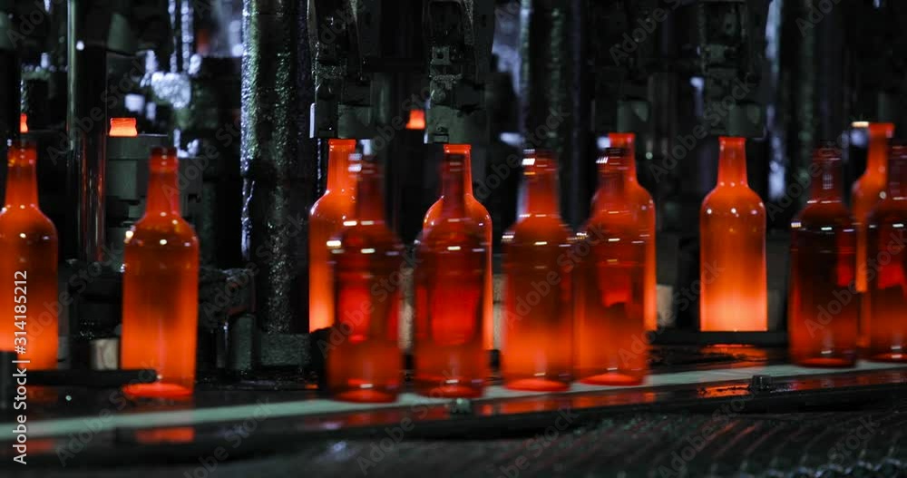 Automated process of forming bottle of molten glass. Molten glass mass ...