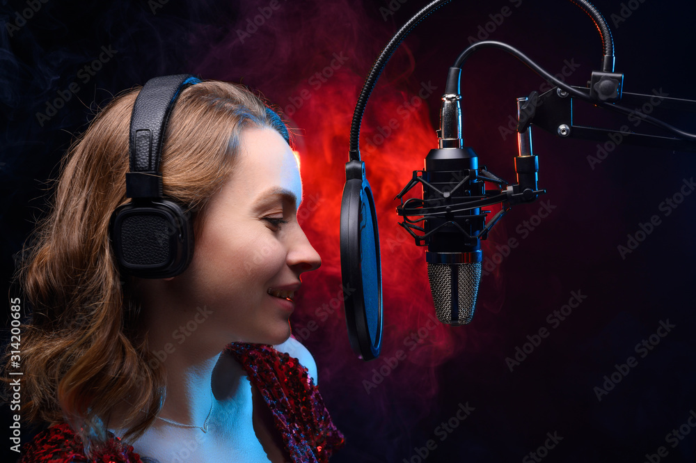 Vocal teacher singing with a studio microphone in a studio with a ...