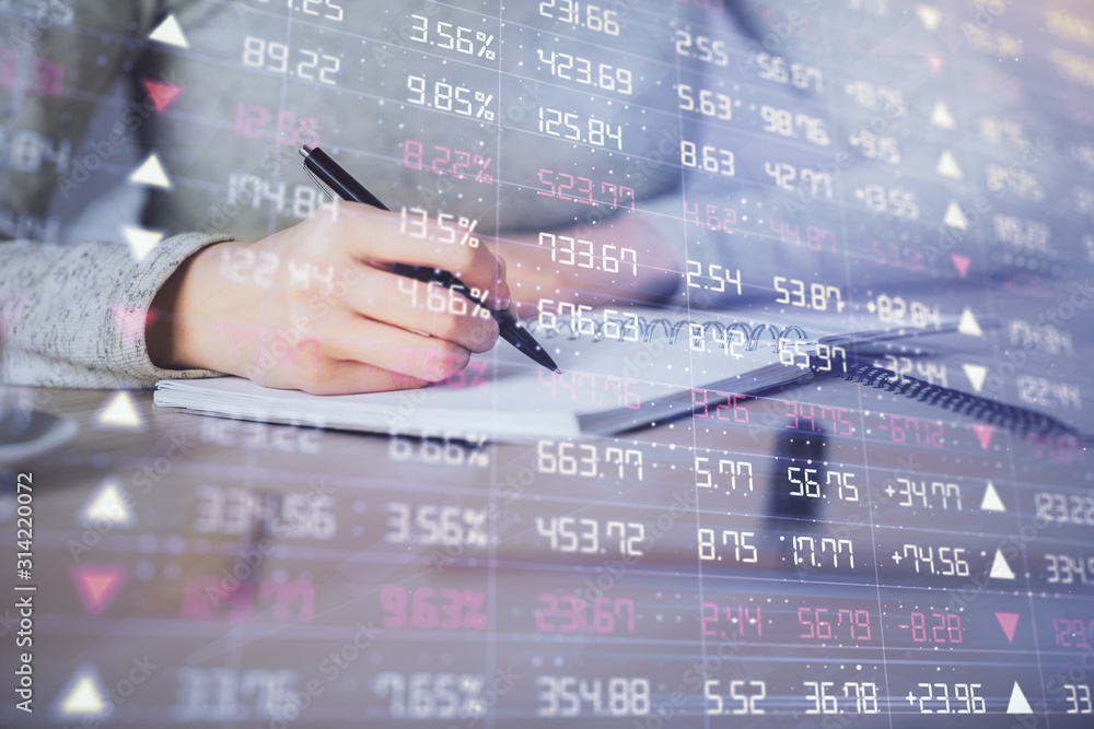 Hands writing information about stock market in notepad. Forex chart ...