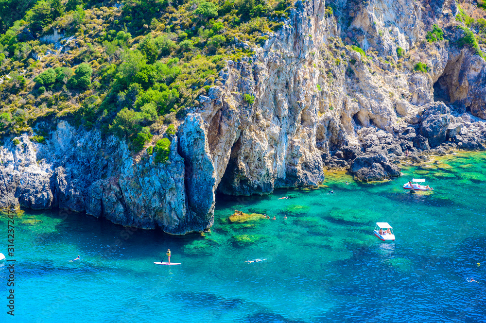 Agios Spiridon Beach with crystal clear azure water and white beach in beautiful landscape ...